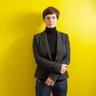 Elena Makartūra no aprites ekonomikas labdarības organizācijas Ellen MacArthur Foundation, attēlā dzeltenās sienas priekšā