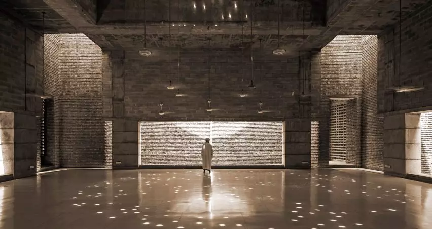 Молитвенный зал мечети Байт-Ур-Руф с солнечным светом, проникающим сквозь кирпичную кладку.