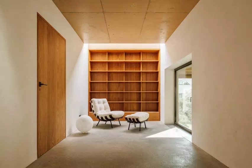 Interiörvy av ett arbetsrum på Casa 2 Porto med inbyggd trähylla och vit fåtölj