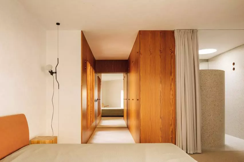 Interiörvy av ett sovrum i trädgårdsannex av Bak Gordon Arquitectos med inbyggda trägarderober