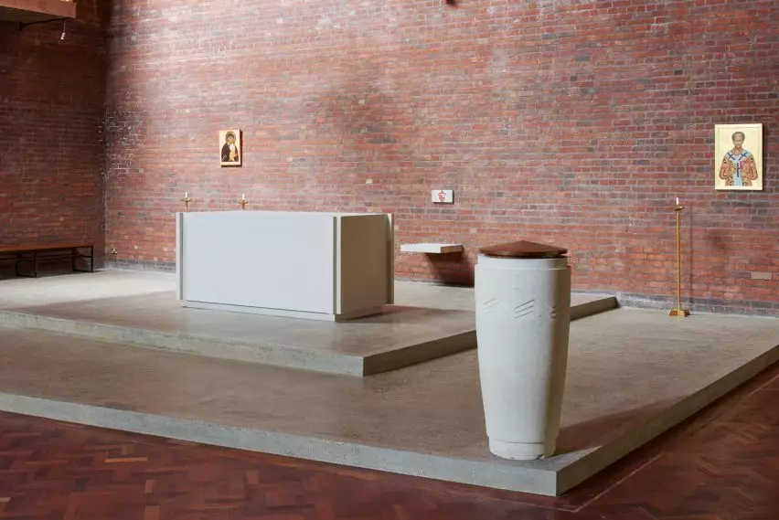 Font de l'església de Sant Joan Crisòstom feta de pedra calcària de Portland amb un altar a joc darrere