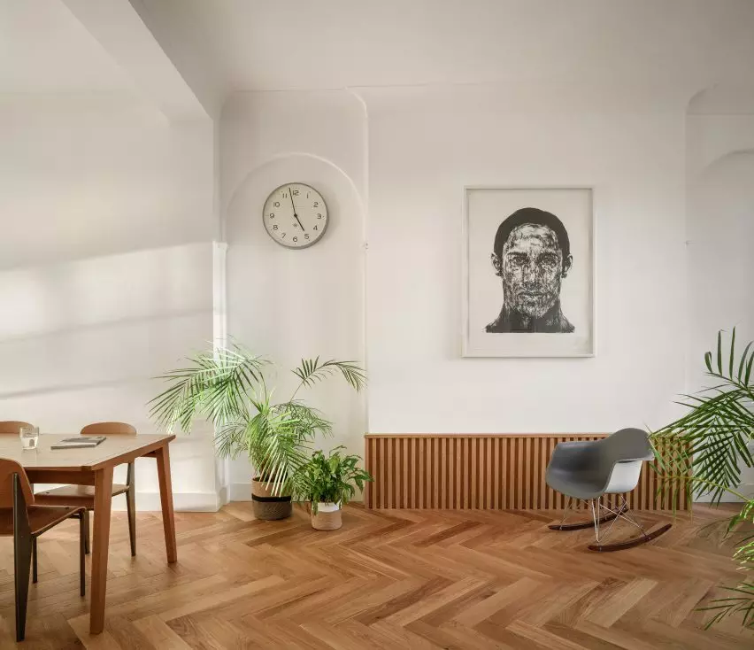 Salon avec table à manger en bois et fauteuil à bascule gris devant une illustration de portrait dans un appartement de Leith du XIXe siècle