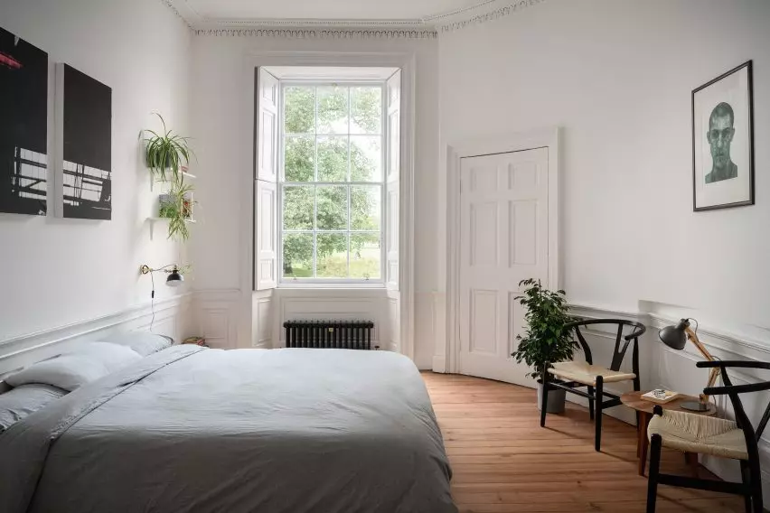 Chambre à coucher de l'appartement d'Édimbourg Luke McClelland avec du pain gris clair et des fauteuils en osier à côté d'une table basse