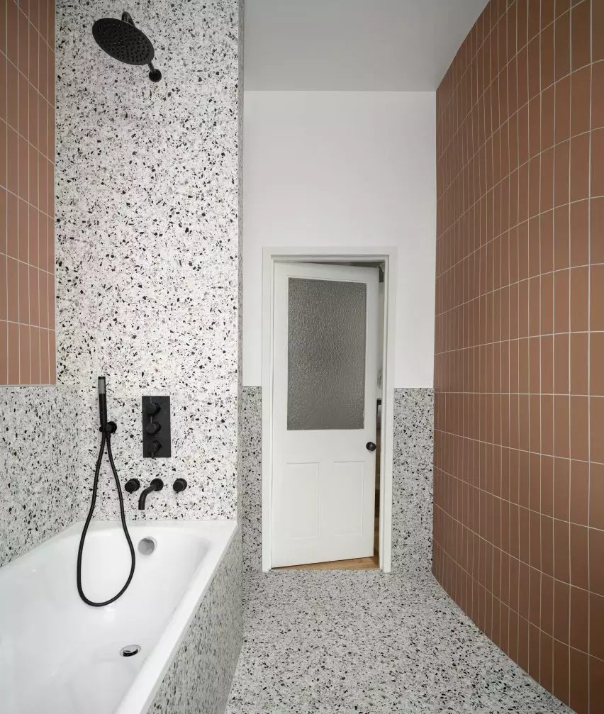 Aménagement d'une salle de bain d'appartement avec un mur incurvé en carrelage en terre cuite et une crédence en terrazzo