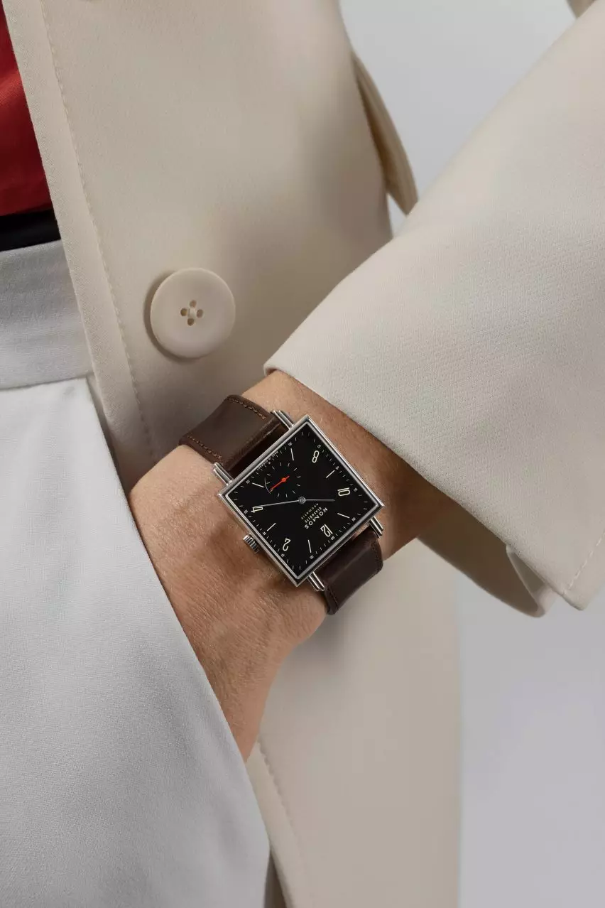 Снимка на някой, който носи черен часовник от Nomos Glashütte