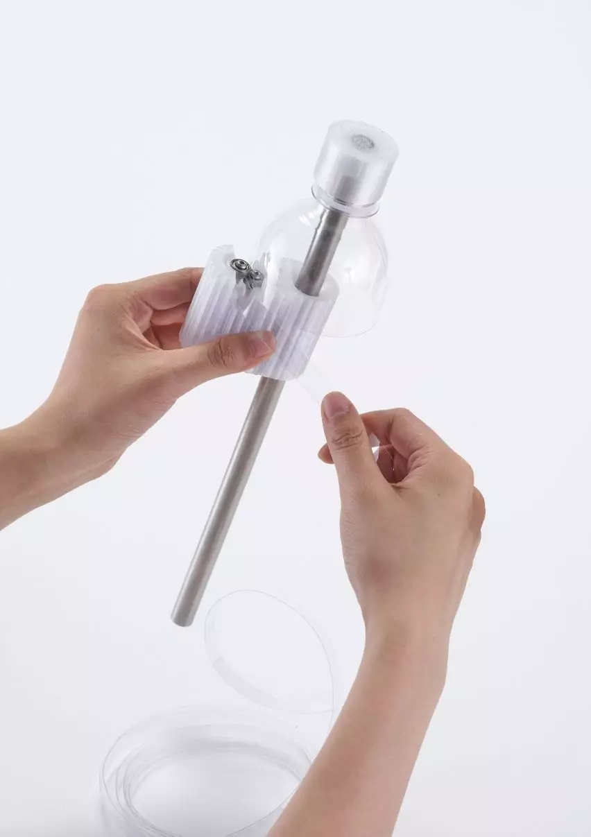 Mâinile tăind o sticlă de plastic folosind rulmenți stivuiți