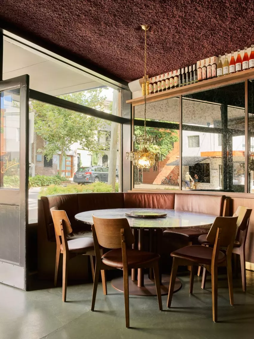 Sedežni prostor s kamnito mizo in lesenimi stoli v baru v Surry Hillsu v Sydneyju, ki ga je oblikoval Luchetti Krelle