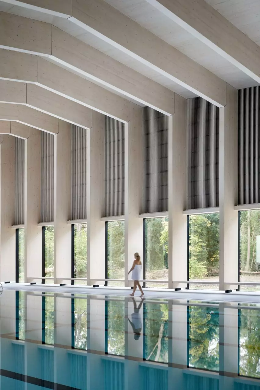 L'empresa britànica Hawkins\Brown ha acabat un edifici de piscina en una escola de Surrey, Anglaterra, amb un marc de fusta vist que incorpora finestres que donen al bosc circumdant.