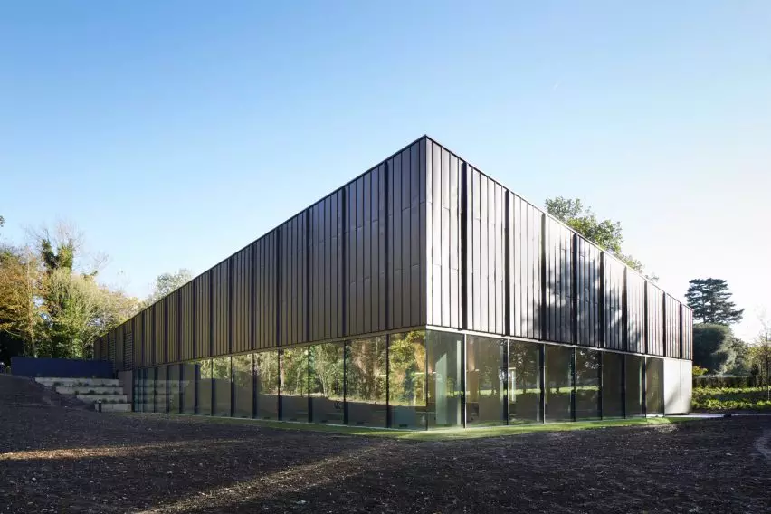 L'empresa britànica Hawkins\Brown ha acabat un edifici de piscina en una escola de Surrey, Anglaterra, amb un marc de fusta vist que incorpora finestres que donen al bosc circumdant.