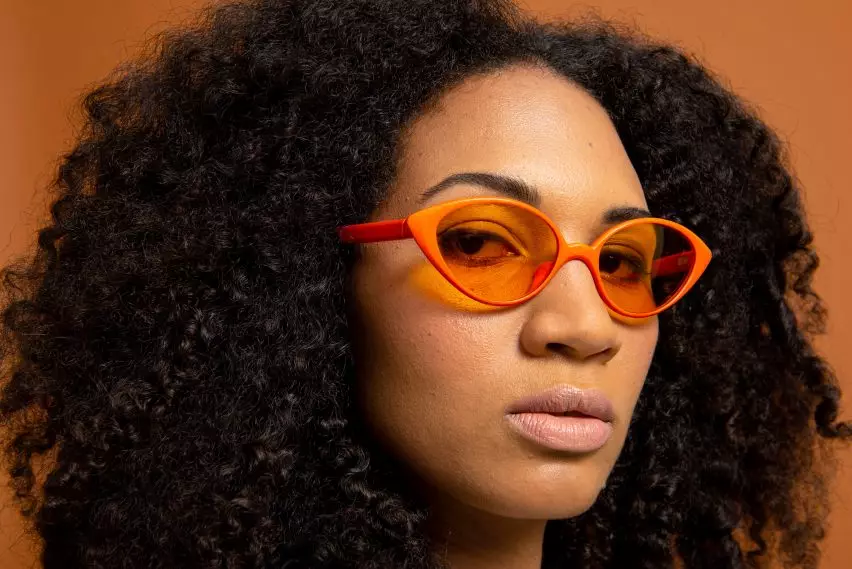 Une femme portant une paire de lunettes de soleil Reframd orange