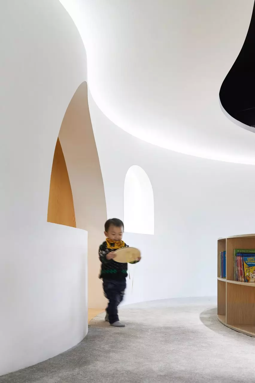 Os recunchos curvos forrados de madeira crean petos de lectura privados na biblioteca infantil de Shanghai 30174_5