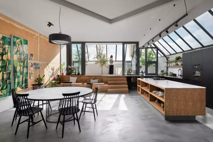 Cocina de planta abierta con mesa de comedor redonda e interior de isla abierta por Valentino Architects