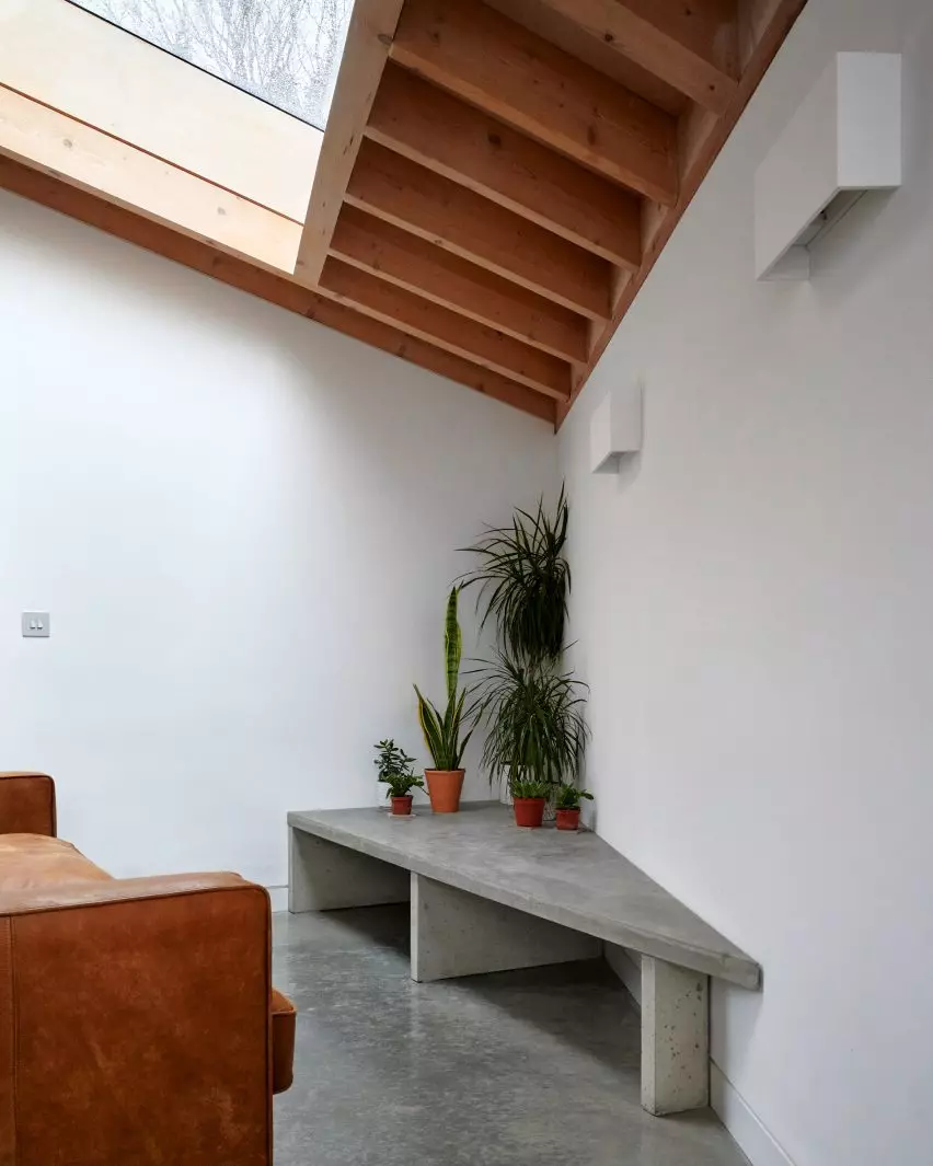 Un espace de vie aux murs blancs avec un plafond en bois