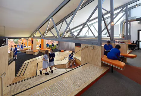Biblioteca escolar revestida de fusta estesa a les copes dels arbres per Branch Studio Architects