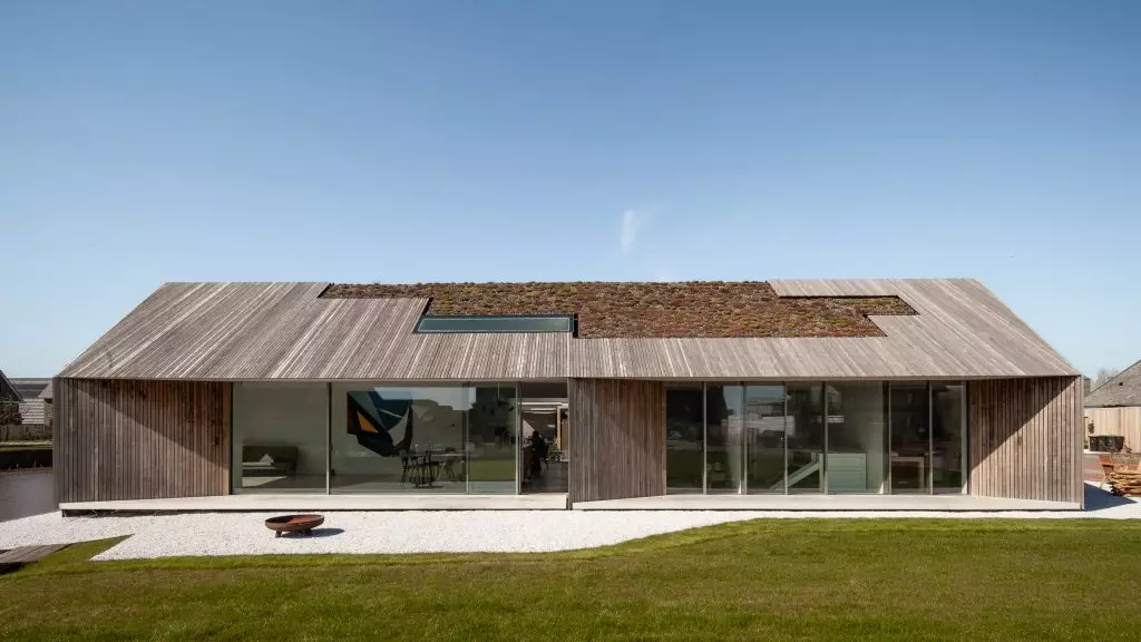 Villa K2 é uma casa revestida de madeira com um telhado de várias águas