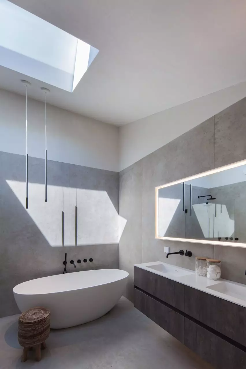 O banheiro da casa revestida de madeira tem um visual contemporâneo