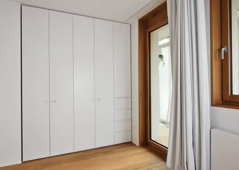 Studio 360 agrega paredes de estanterías modulares y almacenamiento a un apartamento esloveno