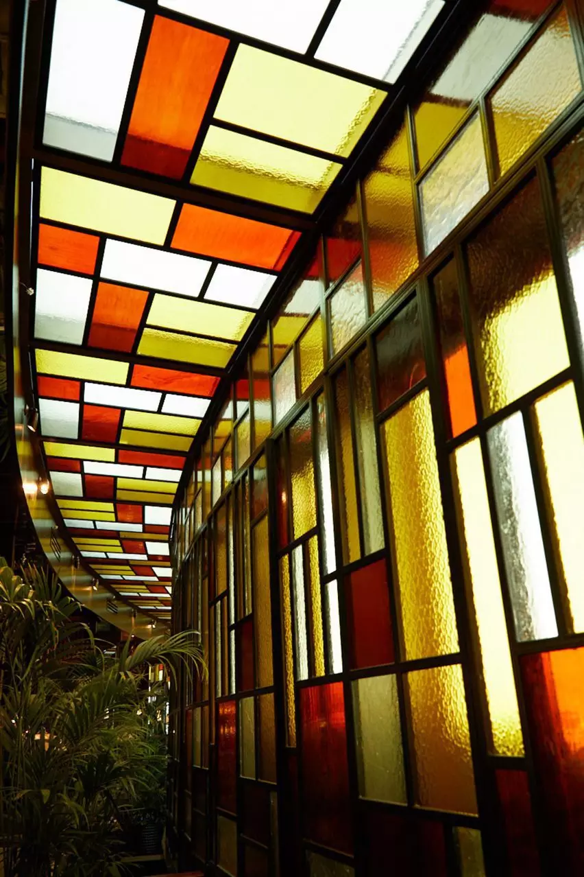 קיר של חלונות ויטראז' בפנים המסעדה מאת Pirajean Lees