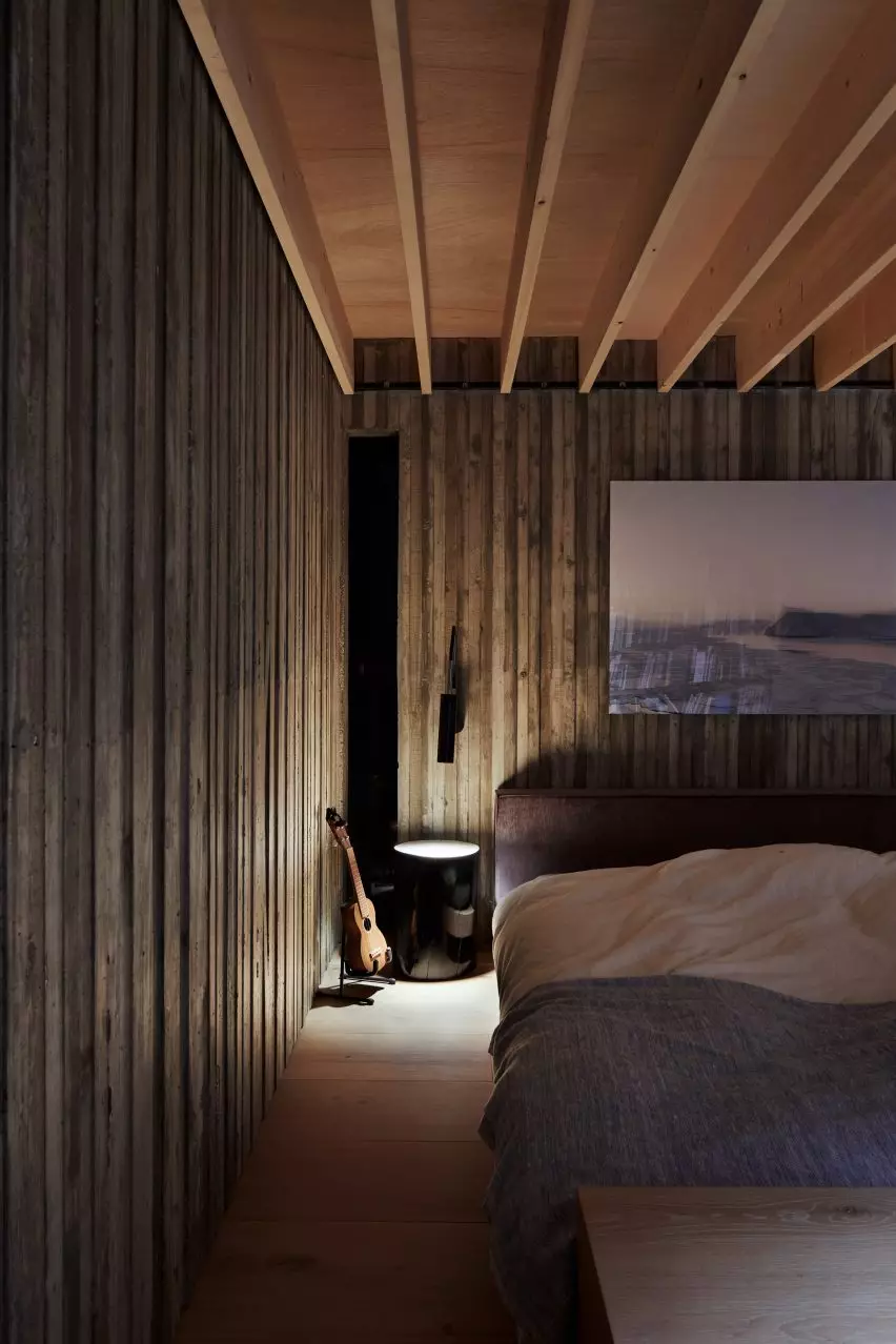 Ein dunkles, mit Holz verkleidetes Schlafzimmer