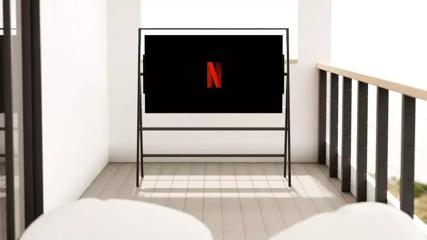 স্ক্রিনে Netflix লোগো সহ একটি ব্যালকনিতে বসানো ইজেল OLED ডিসপ্লে৷