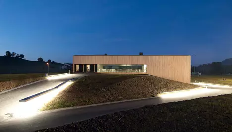 Holzwände weisen schmale vertikale Schnitte in der Lussy Sports Hall von Virdis Architecture auf