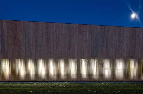 Holzwände weisen schmale vertikale Schnitte in der Lussy Sports Hall von Virdis Architecture auf