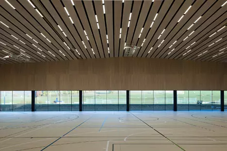 Holzwände weisen schmale vertikale Schnitte in der Lussy Sports Hall von Virdis Architecture auf