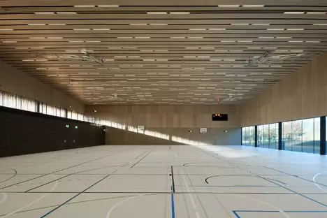 Holzwände weisen schmale vertikale Schnitte in der Lussy Sports Hall von Virdis Architecture auf