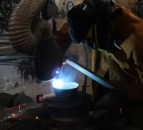 Josh Bitelli folosește echipamente de sudură pentru a face containere din bobine de oțel topit